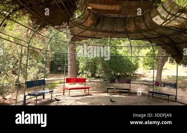 Empty benches under a shaded canopy structure Stock Video Footage - Alamy