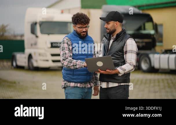 Two professional male truck drivers discussing shipping routes and ...