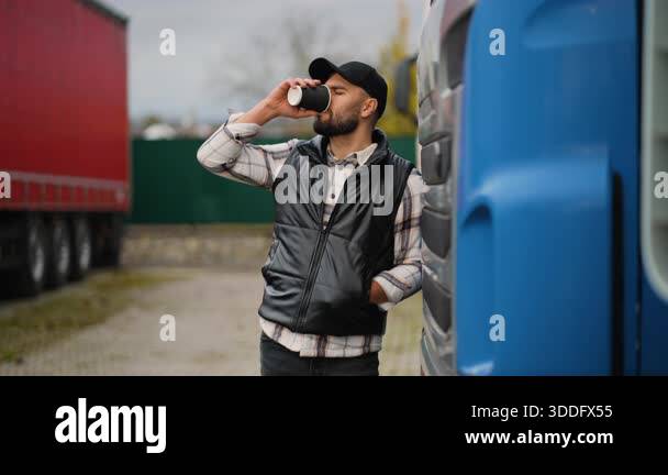 Professional male driver taking a rest, drinking coffee from a paper ...