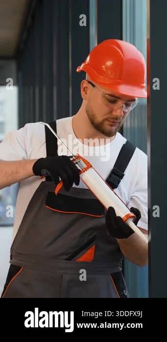 Professional builder wearing a hard hat and safety glasses preparing a ...