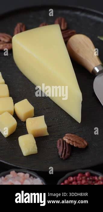 Cubed cheddar, gouda, or parmesan cheese on a cutting board. Cubed ...