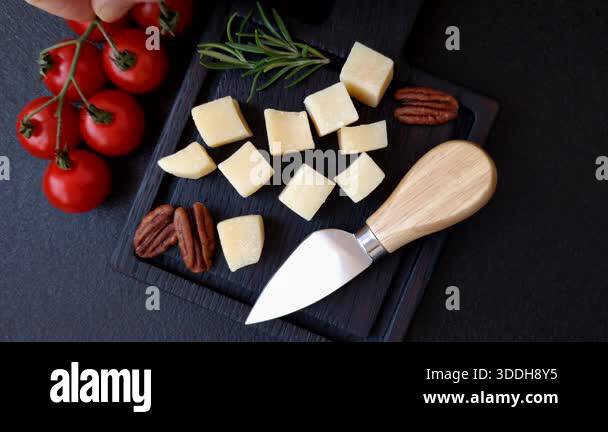 Cubed cheddar, gouda, or parmesan cheese on a cutting board. Cubed ...