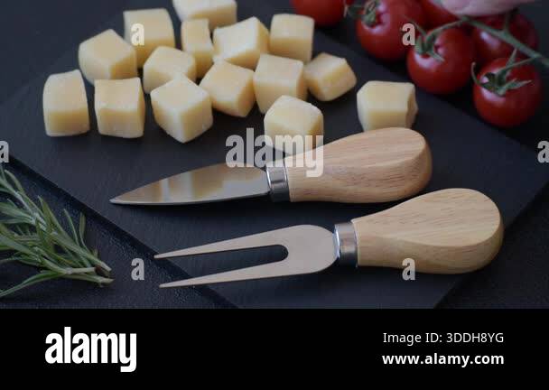 Cubed cheddar, gouda, or parmesan cheese on a cutting board. Cubed ...