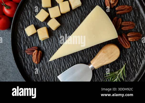 Cubed cheddar, gouda, or parmesan cheese on a cutting board. Cubed ...