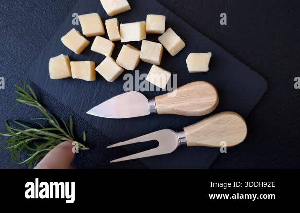 Cubed cheddar, gouda, or parmesan cheese on a cutting board. Cubed ...