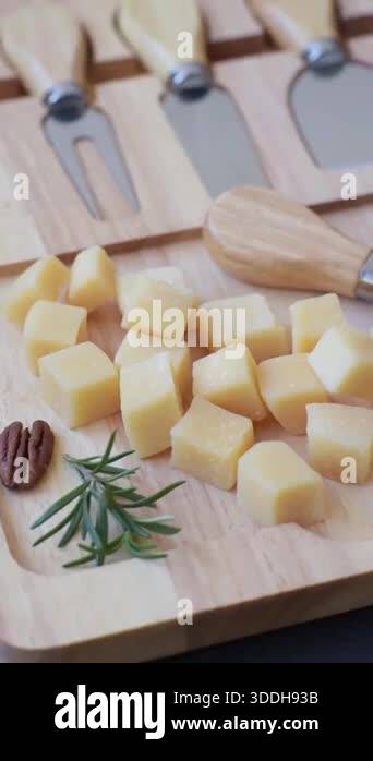 Cubed cheddar, gouda, or parmesan cheese on a cutting board. Cubed ...