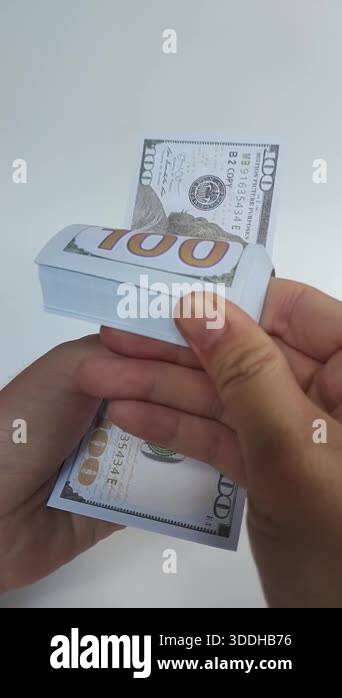 close-up of a hand flipping through a stack of U.S. one hundred dollar ...