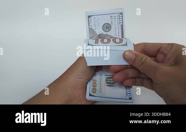 close-up of a hand flipping through a stack of U.S. one hundred dollar ...