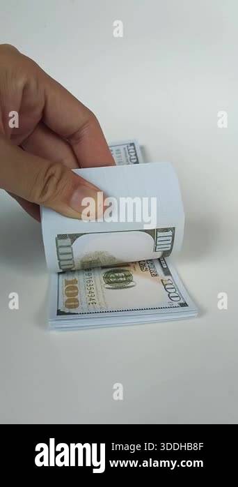 A close-up photo of a hand flipping through a stack of U.S. one hundred ...