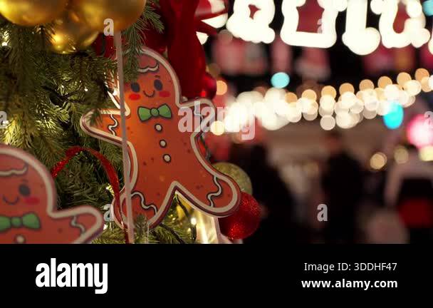 Gingerbread man ornament hanging on Christmas tree with warm festive ...