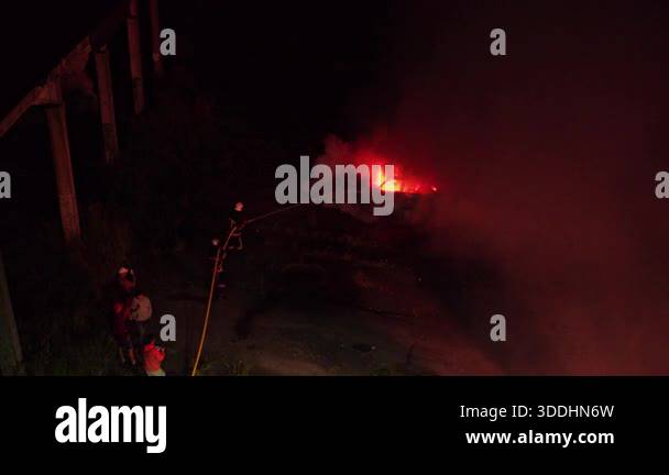 Car on fire. Movie scene. Aerial shot group firefighters in uniform ...