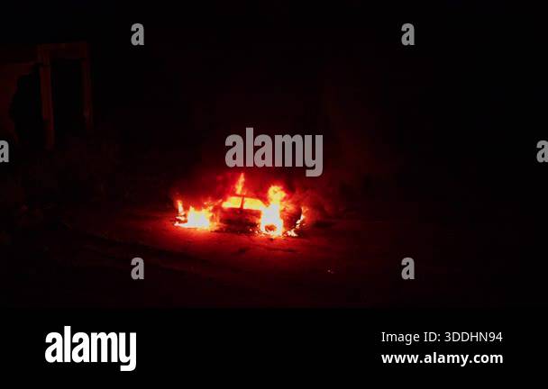 Drone aerial shot of burning car. Exploded destroyed parked old car on ...