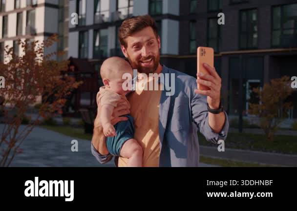 Footage of joyful attractive man holding cute little son. Daddy taking ...