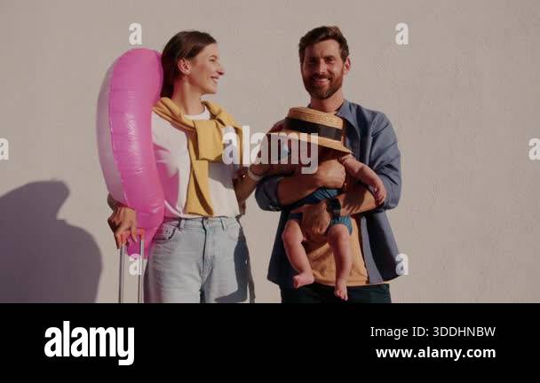 Shot of good-looking happy couple and baby boy looking directly at ...
