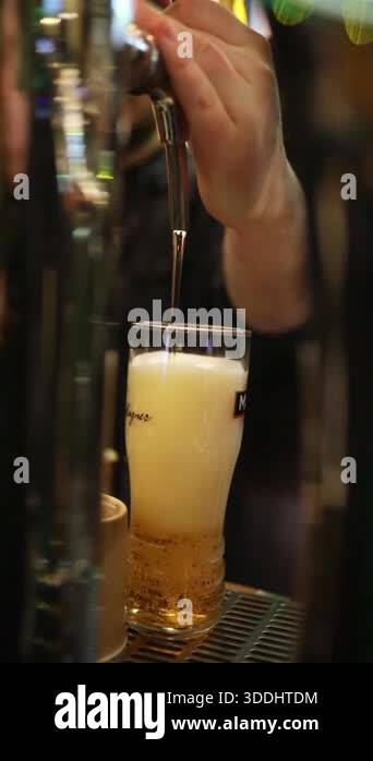 Close-up video of a bartender hand pulling a tap handle as fresh beer ...