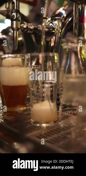 Close-up video of a bartender hand pulling a tap handle as fresh beer ...