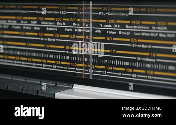 Close-up of an analog radio dial with a red needle moving across ...