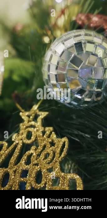 Decorated Christmas tree features a silver disco ball and a golden ...