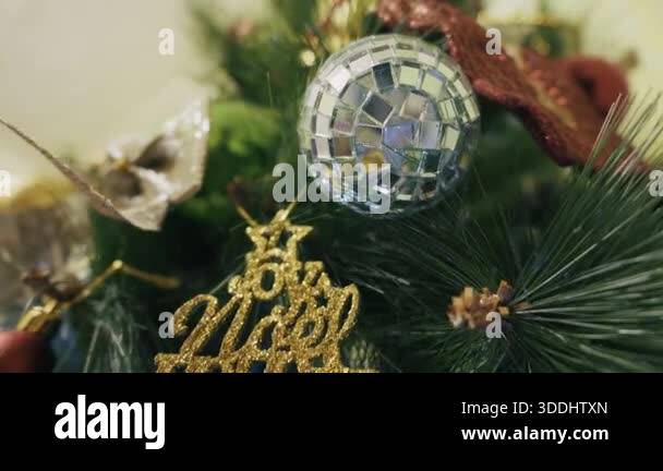 Christmas tree decorations feature a silver disco ball and a gold ...