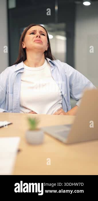 Employee feeling sharp stomach pain while working at laptop in modern ...