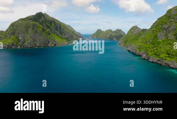 Tapiutan Island and Matinloc Island with rocky coastline and blue sea ...