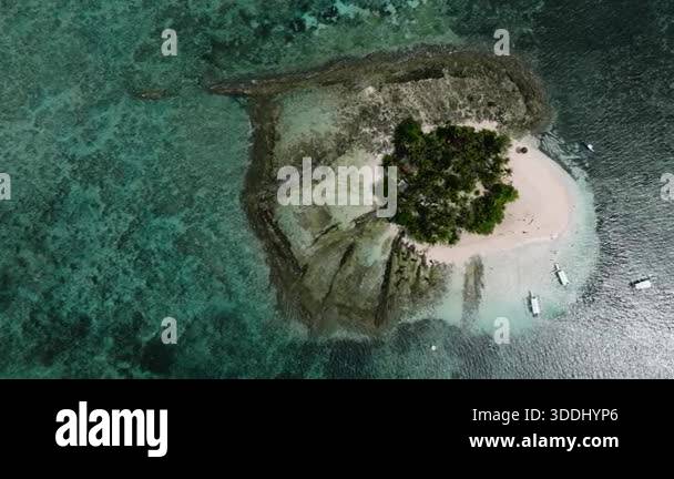Top view of sandy island surrounded by reef and shallow turquoise sea ...