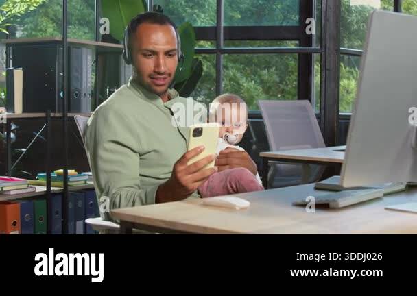 Portrait of busy male sales manager sitting at computer, holding little ...