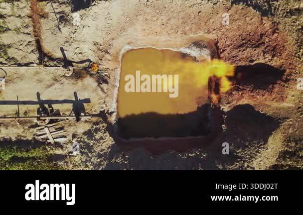 Horizontal footage of industrial landscape. Pit with water and fire ...