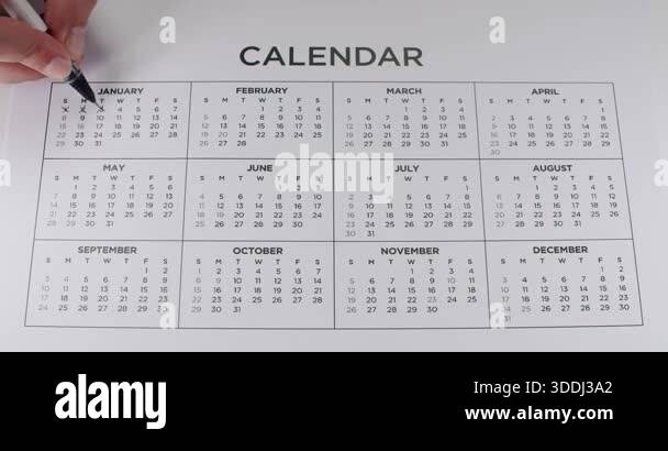 Person marking off days of the month on a white calendar with a black ...