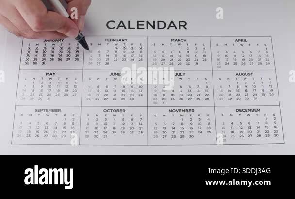 A person uses a black marker to cross off dates on a large printed ...