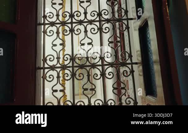 Ornate metal gate with intricate Moroccan design. Sunlight streams ...