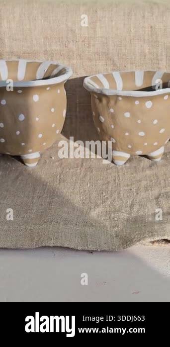 Video shows three handmade clay planters on small legs before kiln ...