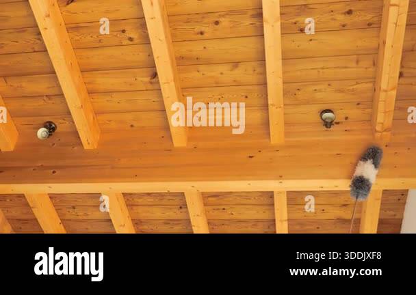 Cleaning wooden ceilings and ceiling lights from dust.Cleaning with a ...