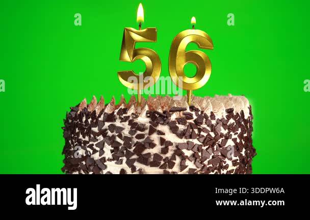 Lighting number 56 golden birthday candle on festive cake. Green screen ...