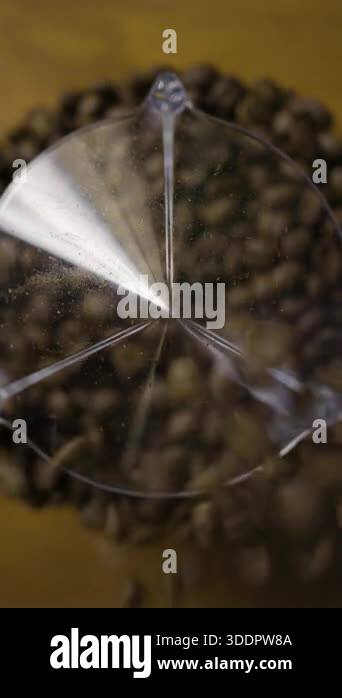 Close up top view of aromatic roasted coffee beans falling into an ...