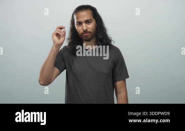 Young arab hispanic man smiling with hand at temple and peace sign ...