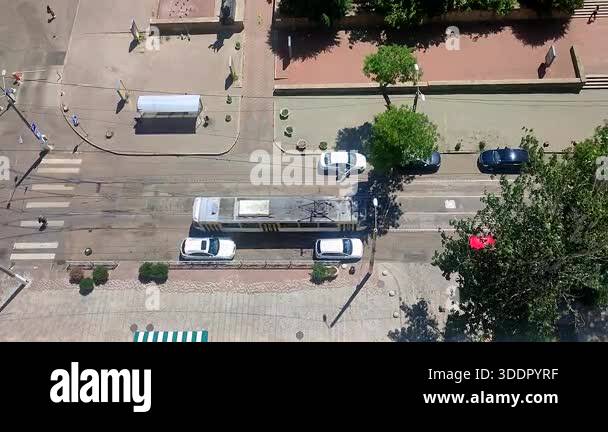 City street and road from above. Asphalt road, moving tram and parked ...