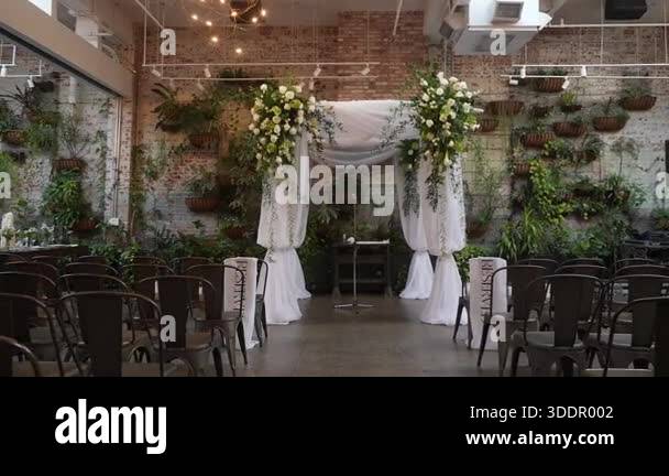 Wide Shot Industrial Loft Ceremony Setup With Draped Arch And Twin ...