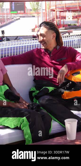Multiracial couple relaxing and talking before a go kart race. Young ...