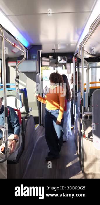 Young diverse people traveling by public transport. A woman paying the ...