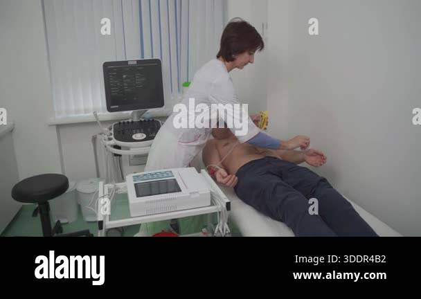Medical equipment for electrocardiogram. Doctors doing ECG test on male ...