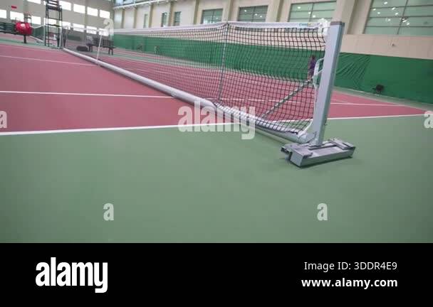 Firm net holds clean straight line within large airy court under crisp ...