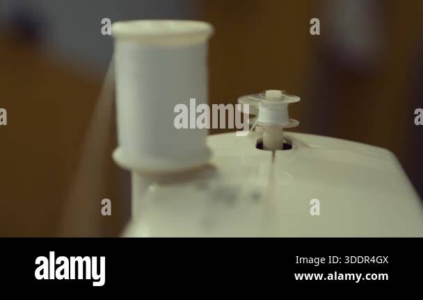 The bobbin is threaded with white thread on the sewing machine Stock ...