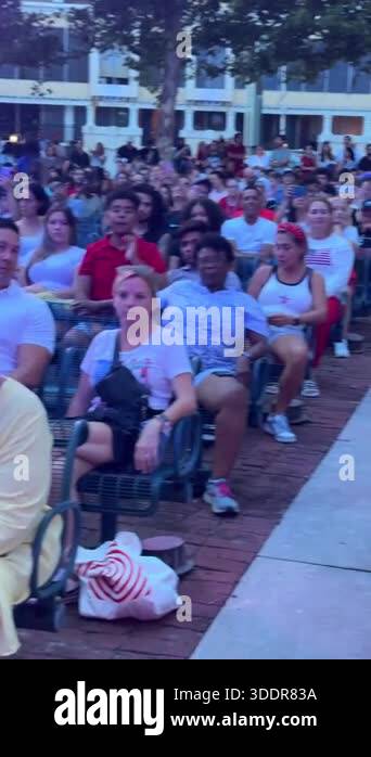 Orlando, Florida - 07.04.2024: A large diverse crowd sits on benches ...