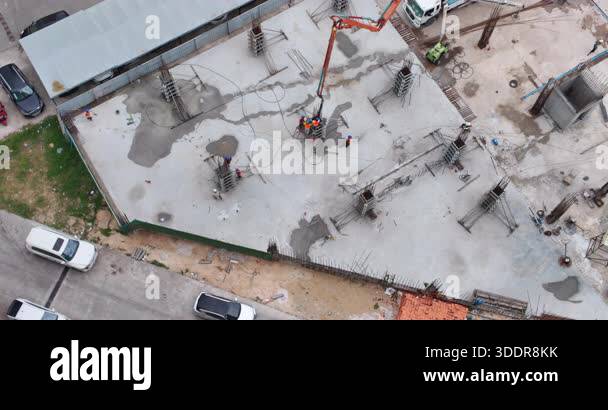 Aerial view of workers pouring concrete into a column formwork Stock ...