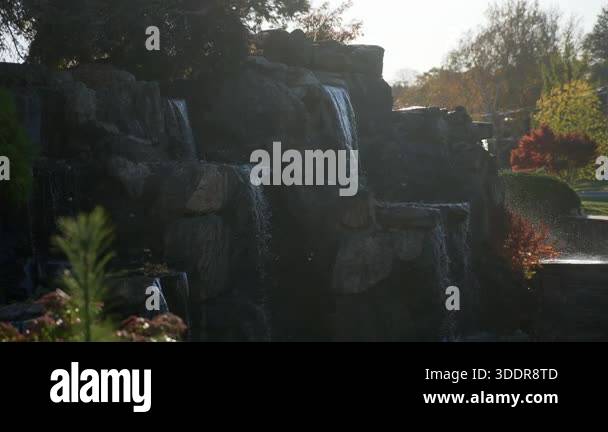 Sunlit Rock Waterfall In Garden, Soft Cascade Over Boulders Into ...