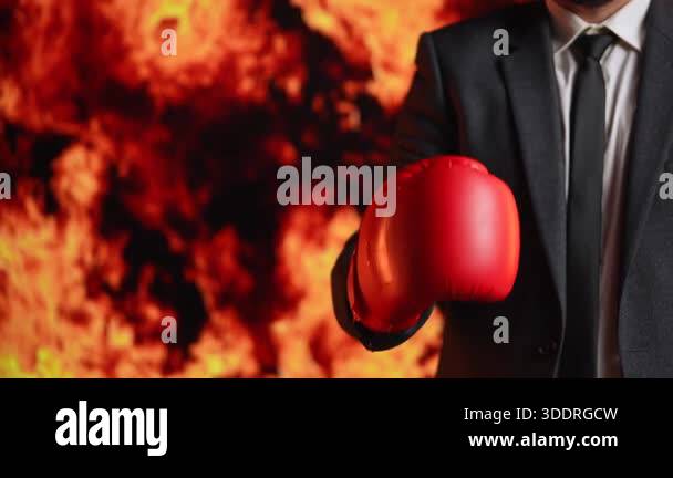 A corporate professional in a suit with a bright red boxing glove ...