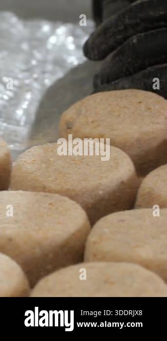 Vertical video. Fresh pale chicken patties carefully aligned on metal ...