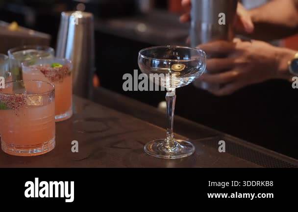 Mixologist Pours Chilled Cocktail Into Coupe On Dim Bar Counter, Shaker ...