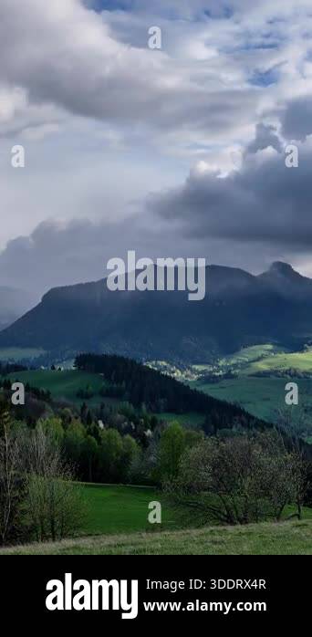 Dramatic spring timelapse of dark rain clouds drifting above a fresh ...